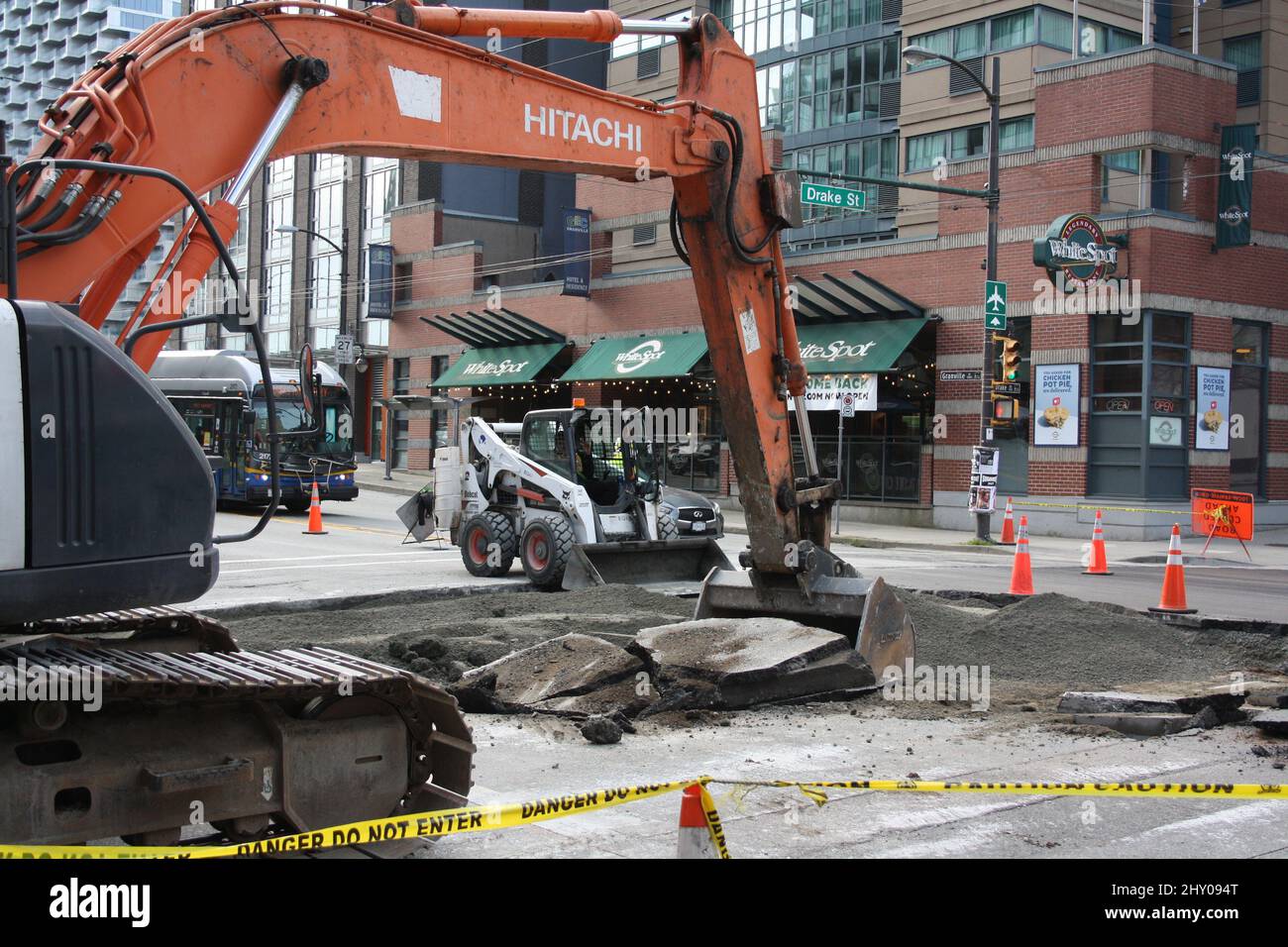 Excavator digging ground in the street of downtown Vancouver, British ...