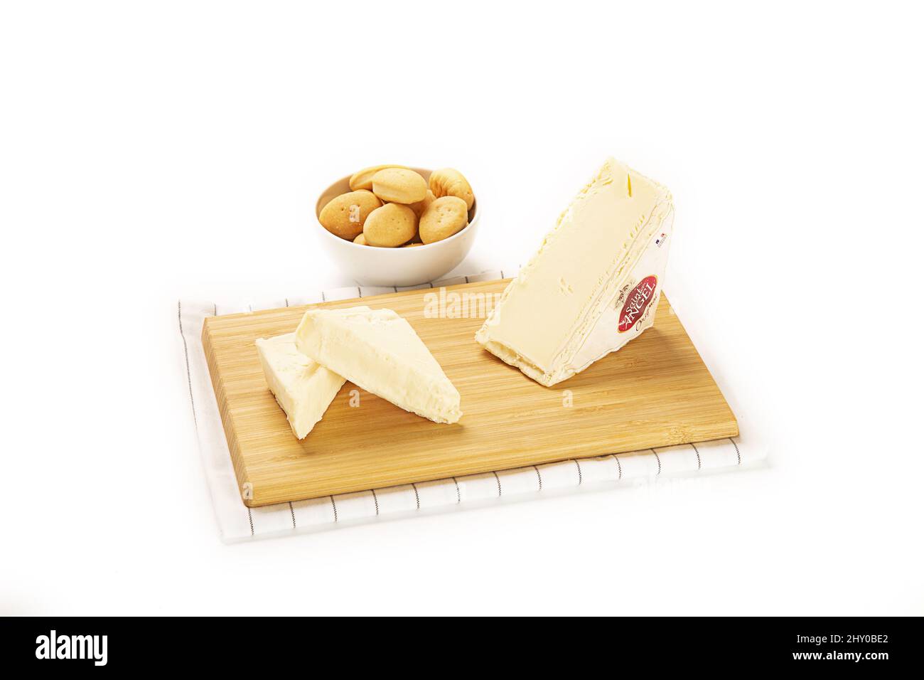 Wooden plank with a piece of cheese and bread on the side isolated on ...