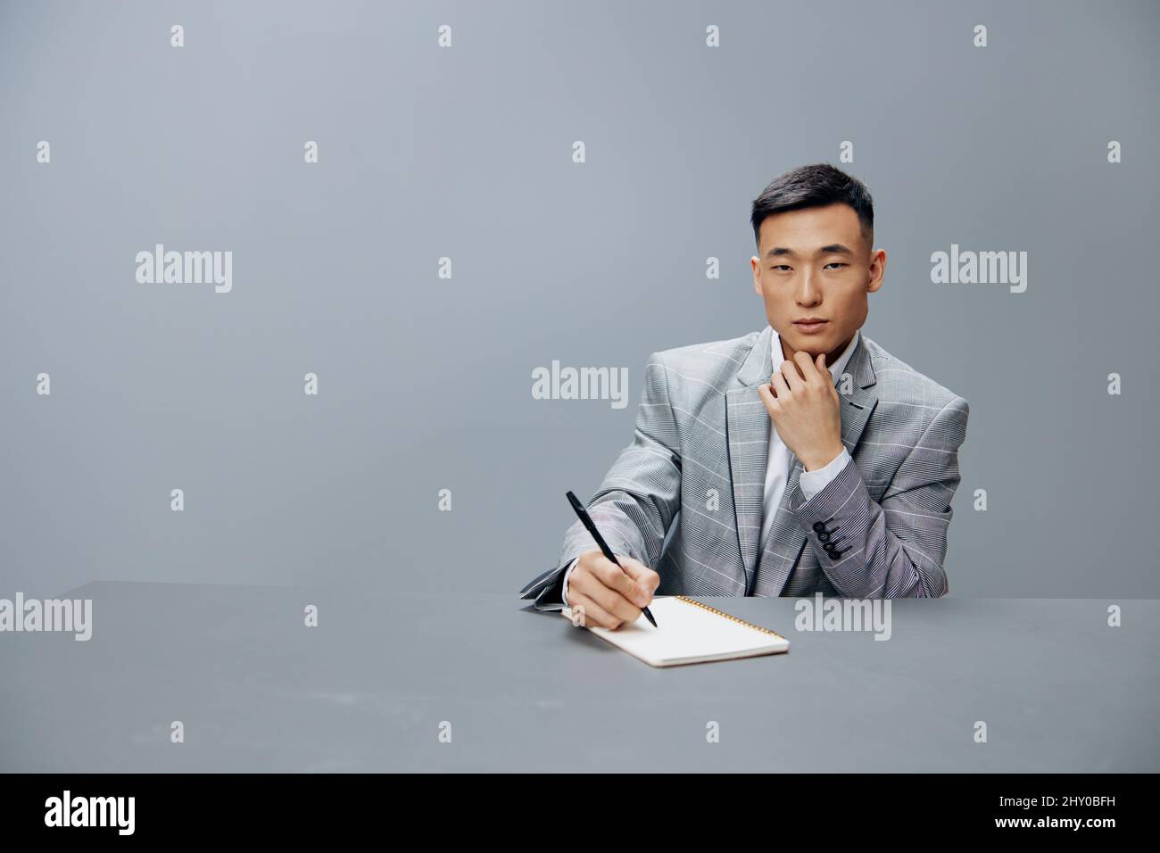 man in a gray suit in the office with a notepad on the table the idea ...