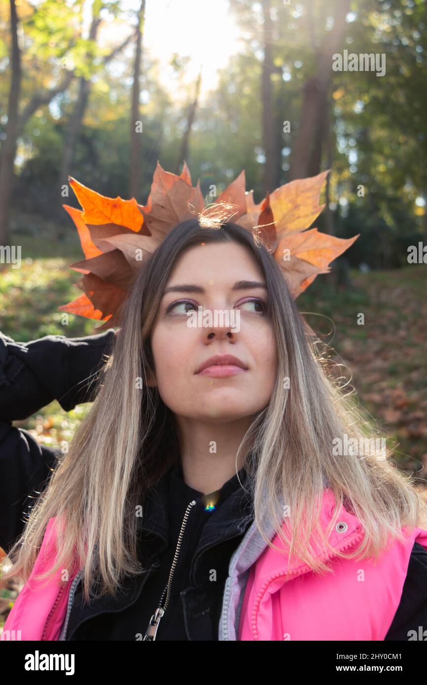 Woman holding fall leaves in forest smiling happy and excited. Portrait ...