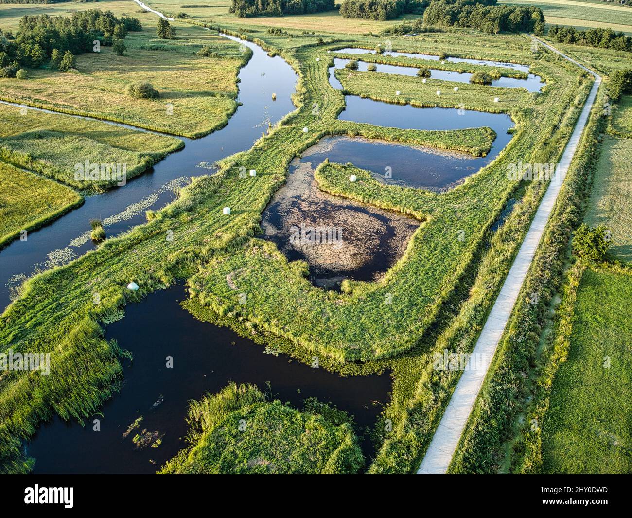 Landscape of peat soil land freshly cut and stacked alongside a bike ...
