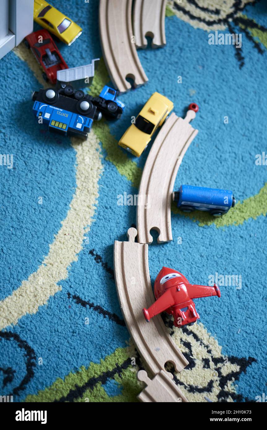 Top view of wooden train tracks and toy vehicles on a carpet floor ...