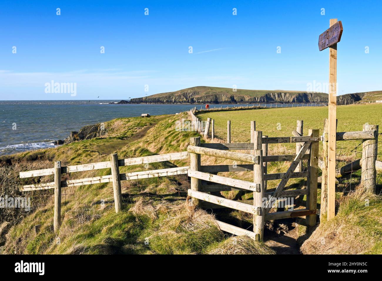 Wooden gate and signpost on the Wales National Coastal Path at Gwbert ...