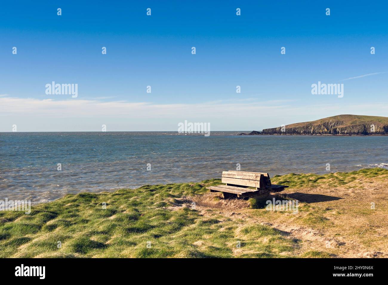 Wooden bench for walkers on the Wales National Coastal Path at Gwbert ...