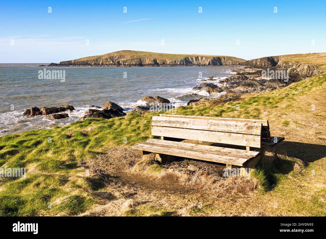 Wooden bench for walkers on the Wales National Coastal Path at Gwbert ...
