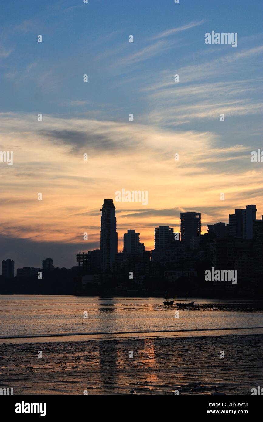 Vertical shot of the silhouettes of skyscrapers reflecting on the ...