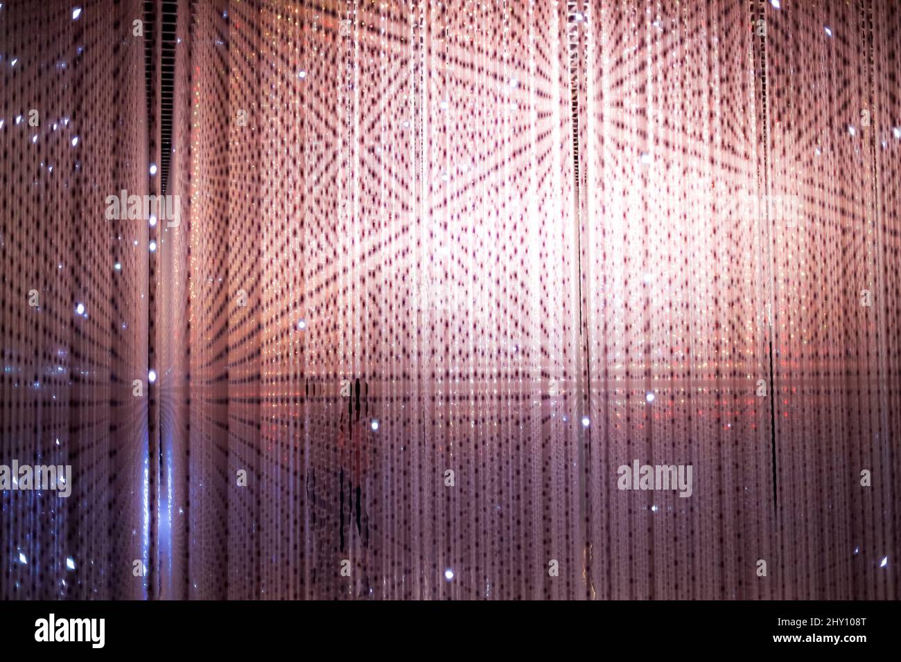 Shot of a person standing in a futuristic pink light labyrinth in an ...