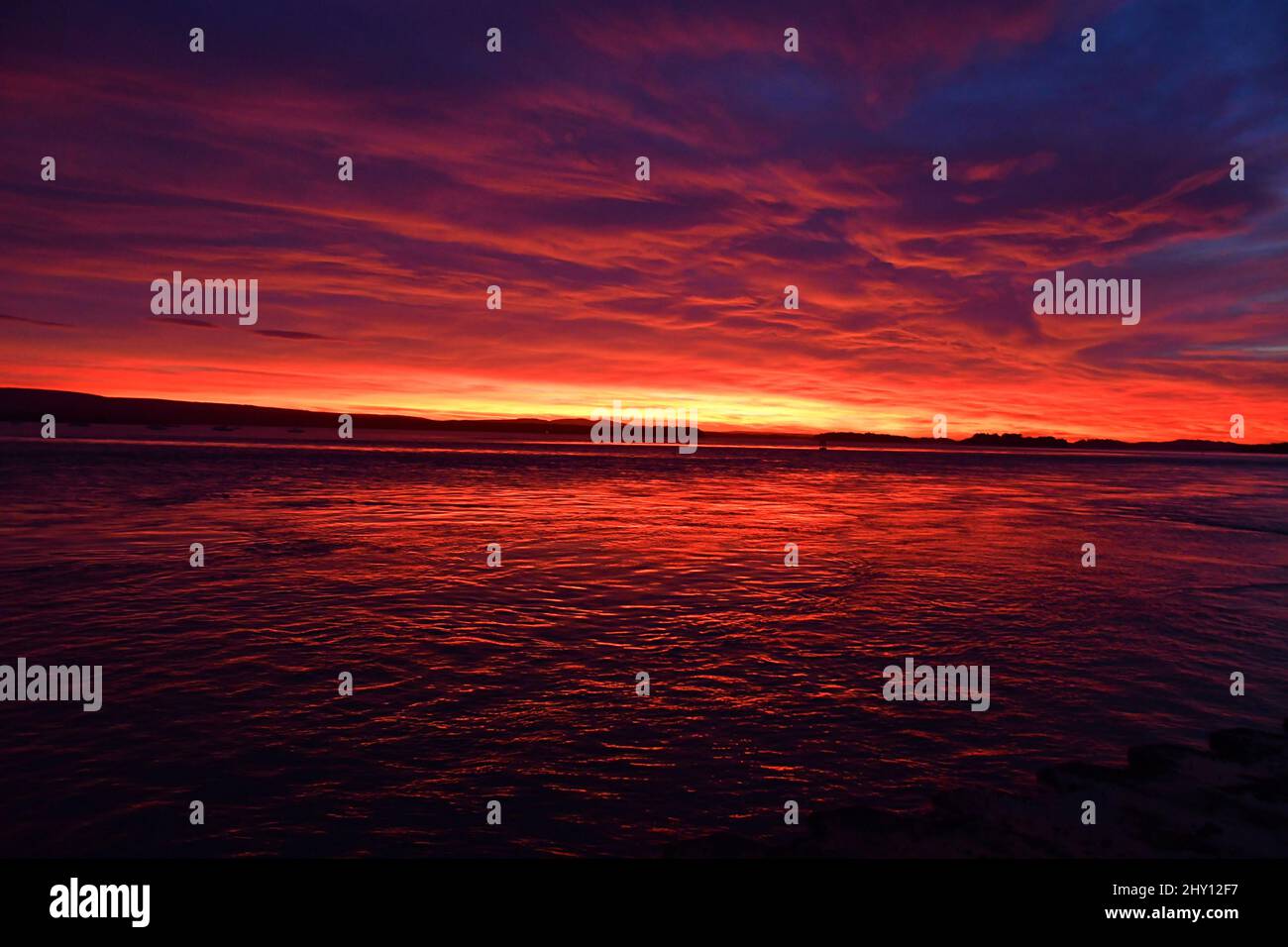 Mesmerizing scene of red horizon sunset cloudy sky reflecting on ocean ...