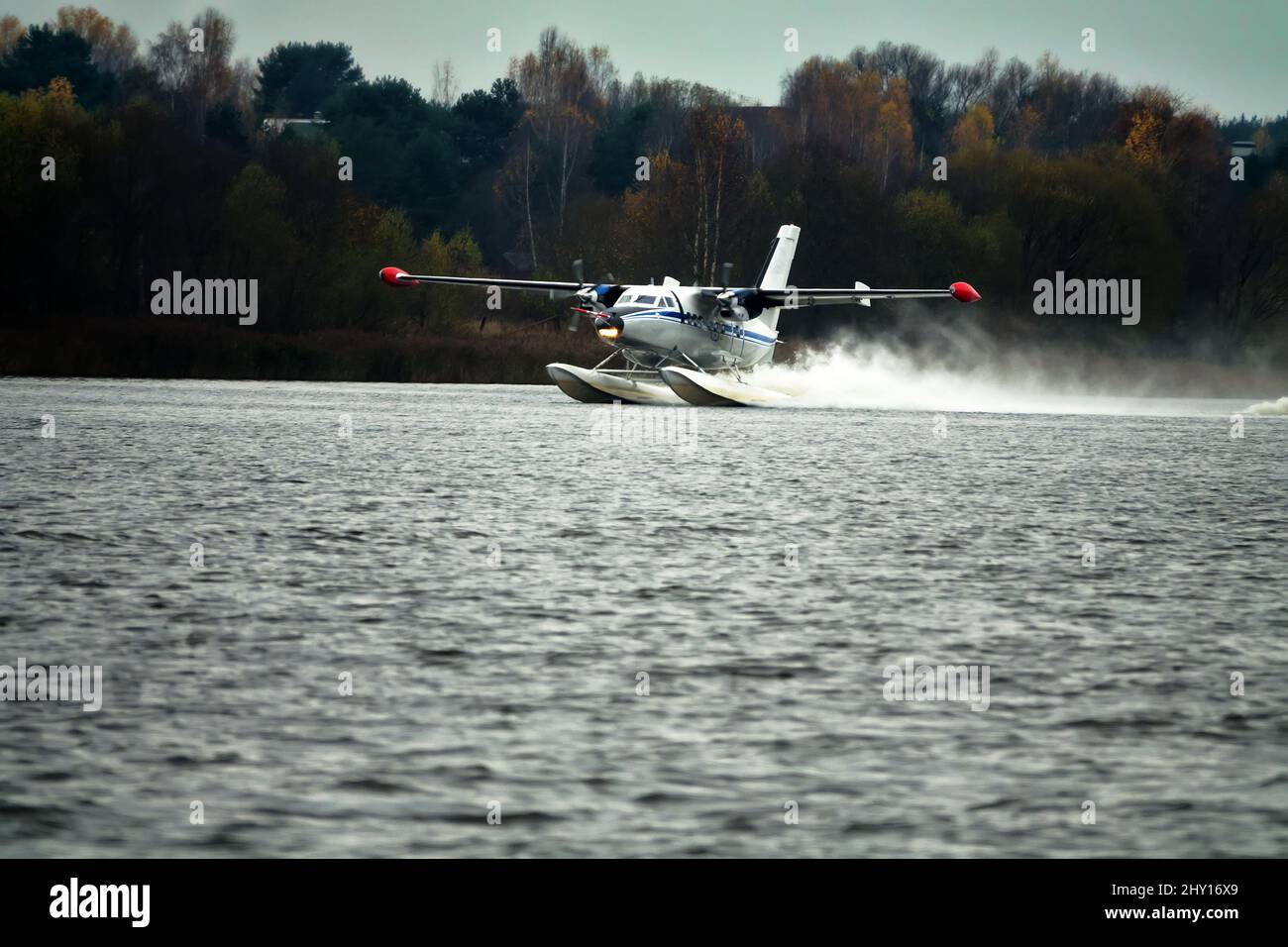 The Twin-engine seaplane a seaplane rises from water, from the forest ...