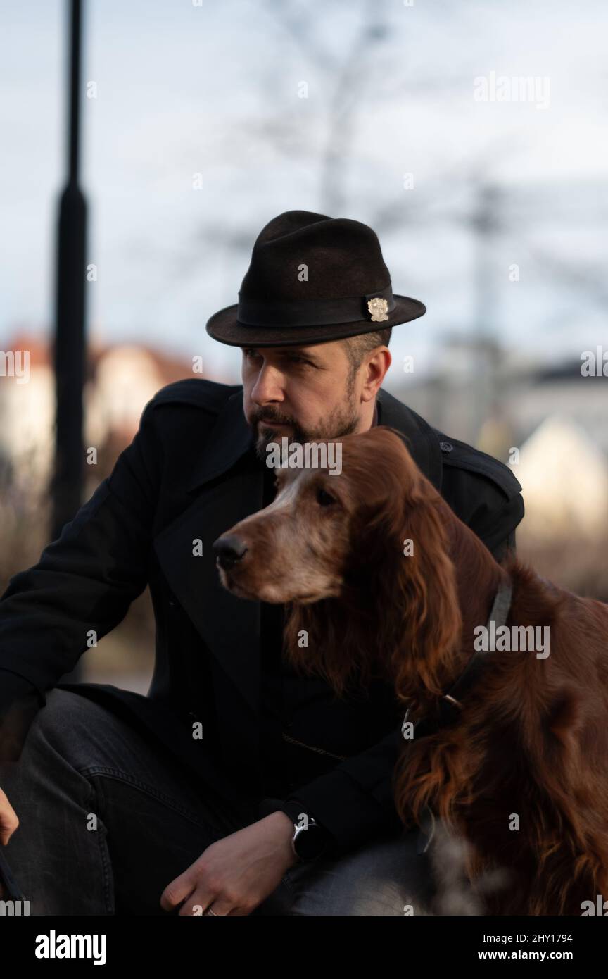 Vertical shot of a Swedish man in a hat with his cocker spaniel Stock ...