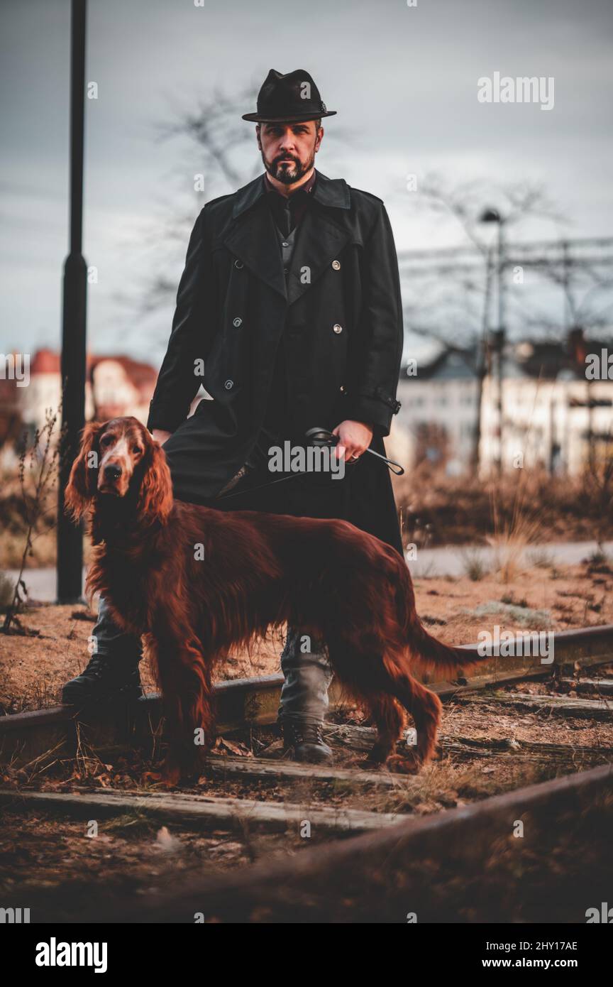 Vertical shot of a Swedish man with a cocker spaniel standing on a ...