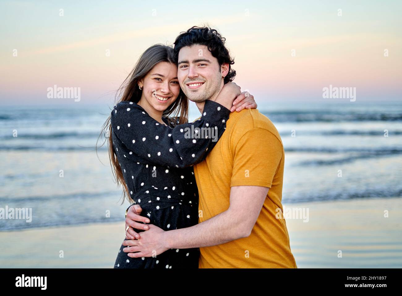 Loving couple in casual wear hugging and tenderly caressing while ...