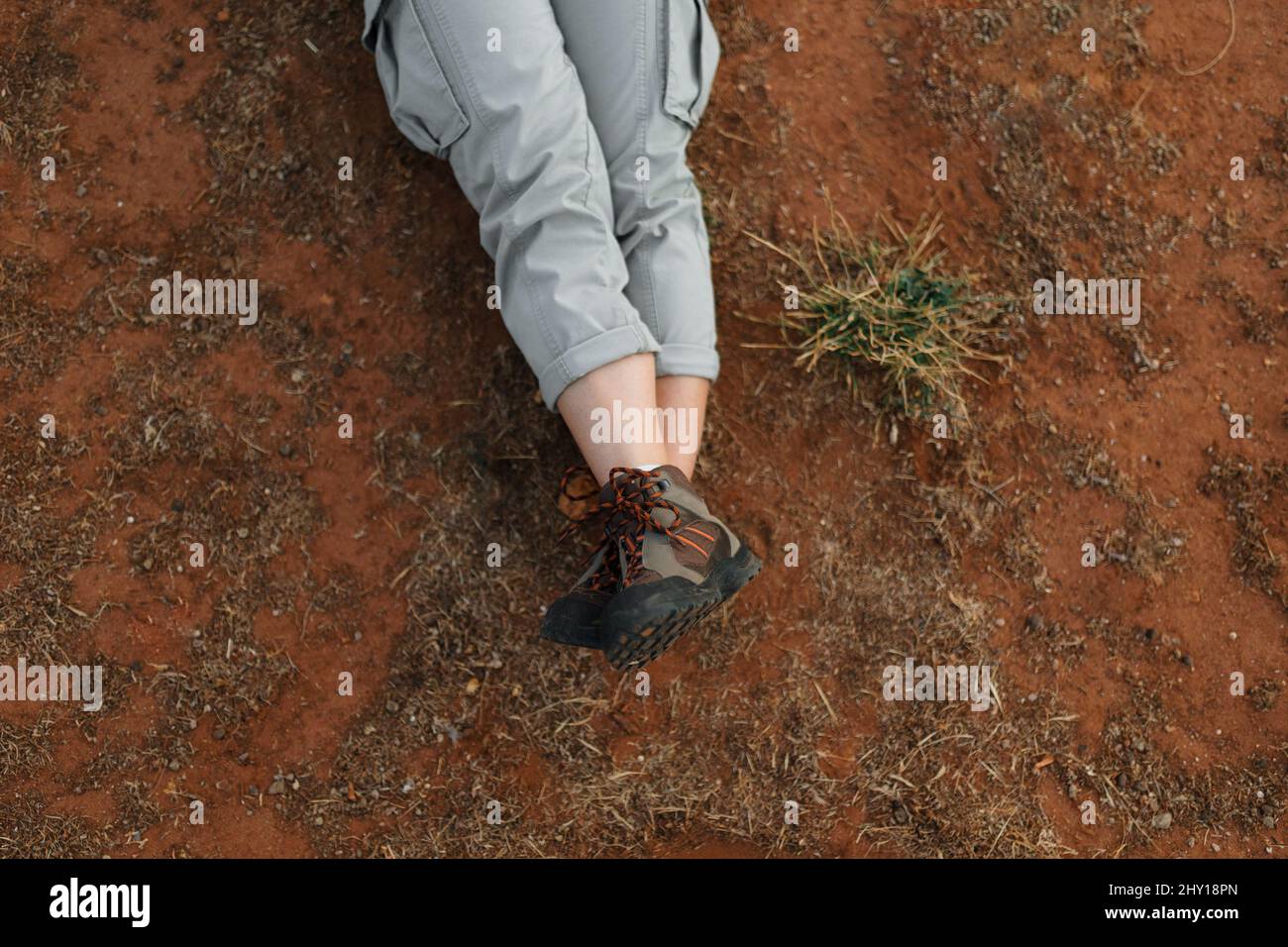 From above cropped unrecognizable female traveler with hiking shoes ...
