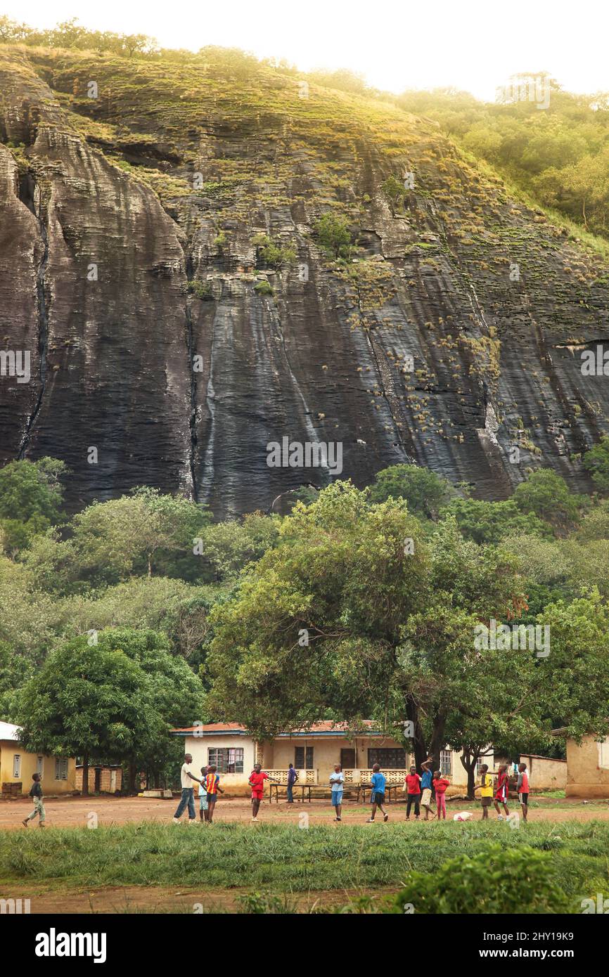 Vertical shot of kids playing by a large cliff Stock Photo - Alamy