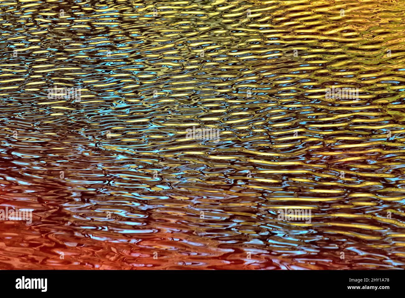 Full frame abstract background of rippling sea with colorful light ...