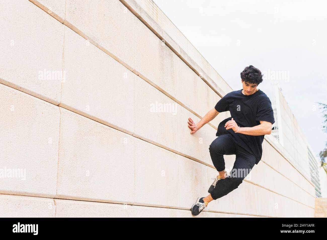 Side view of full length man in black outfit performing acrobatic ...