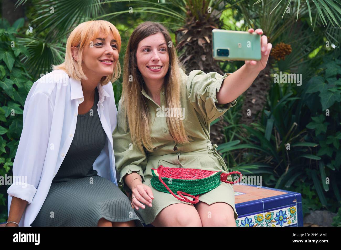 Cheerful Female Friends Taking Self Portrait On Smartphone While