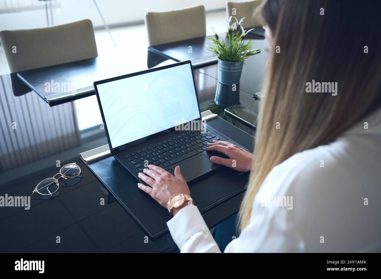 Side view of crop anonymous female employee browsing netbook while ...