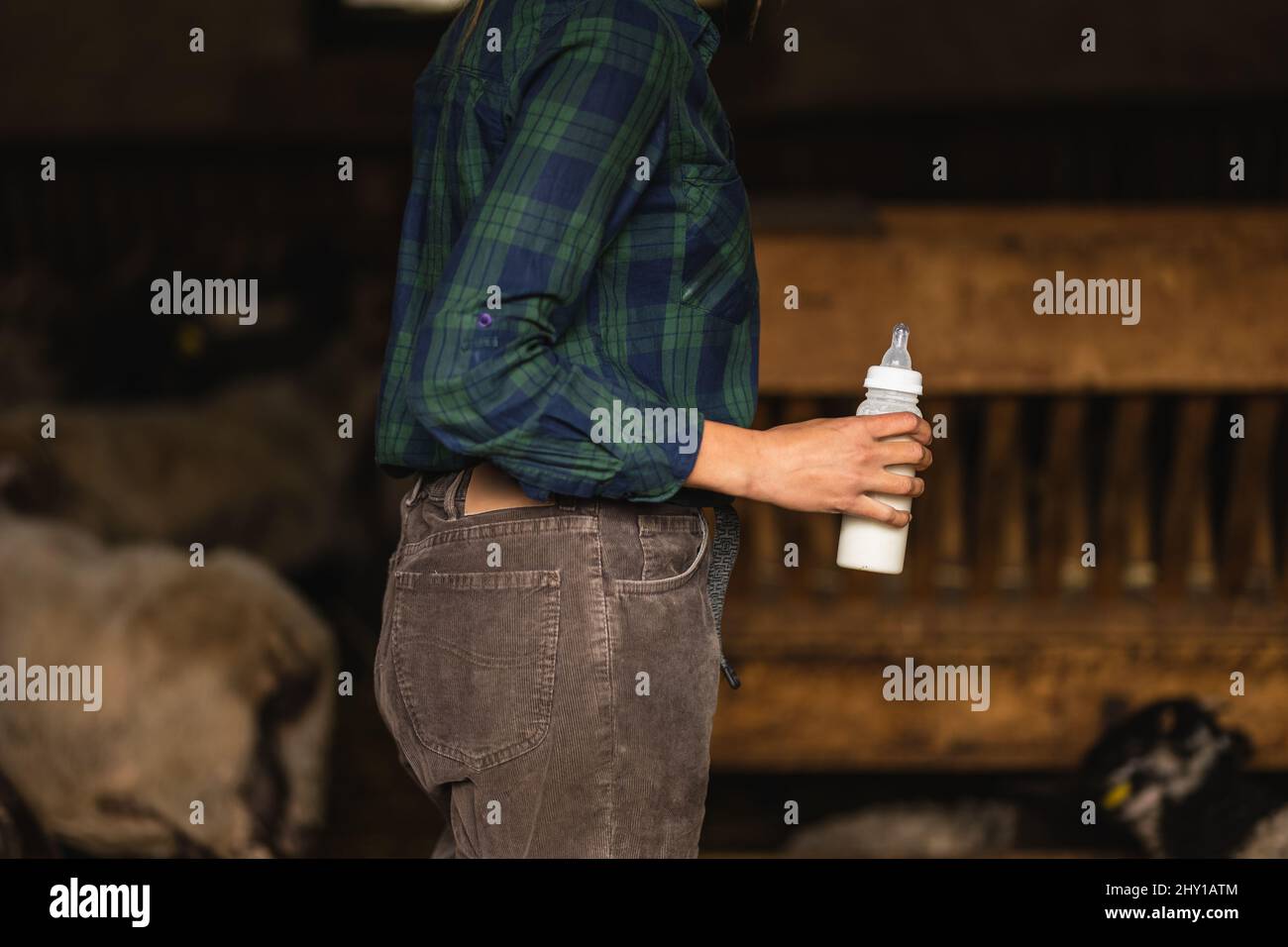 Professional crop anonymous female farmer with milk bottle standing in ...