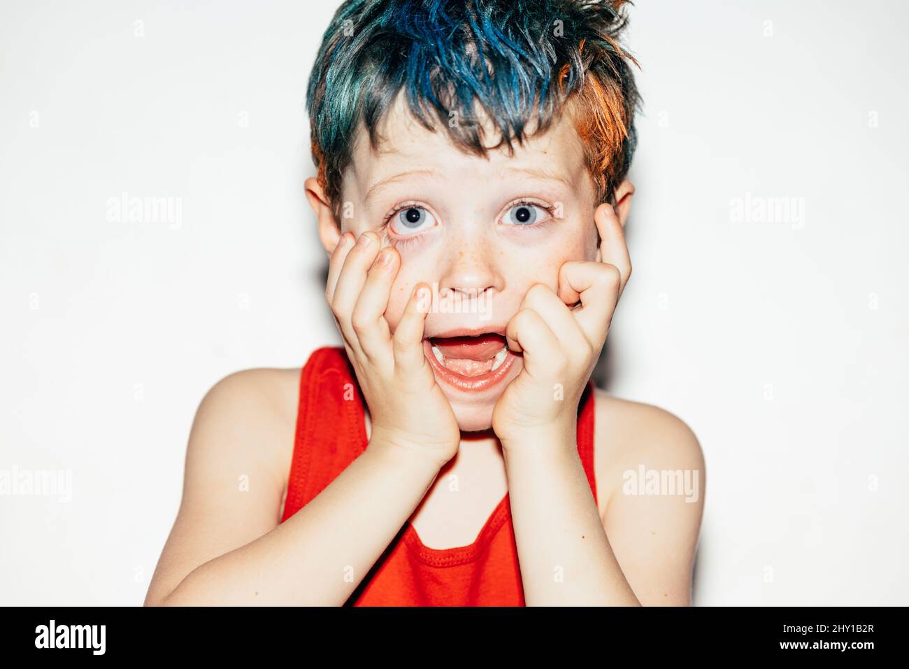 Terrified rebellious boy with dyed hair looking away with fear and ...