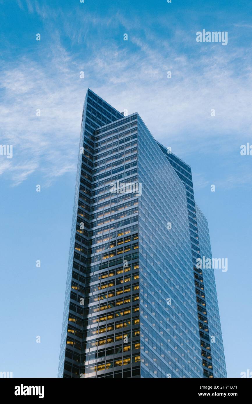 From below of contemporary high rise building with glass mirrored walls ...