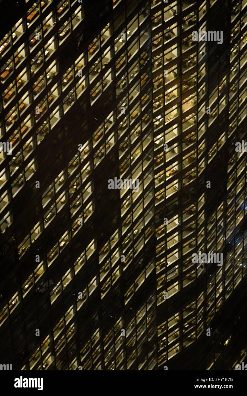 Full frame of modern multistory building with glowing windows located ...