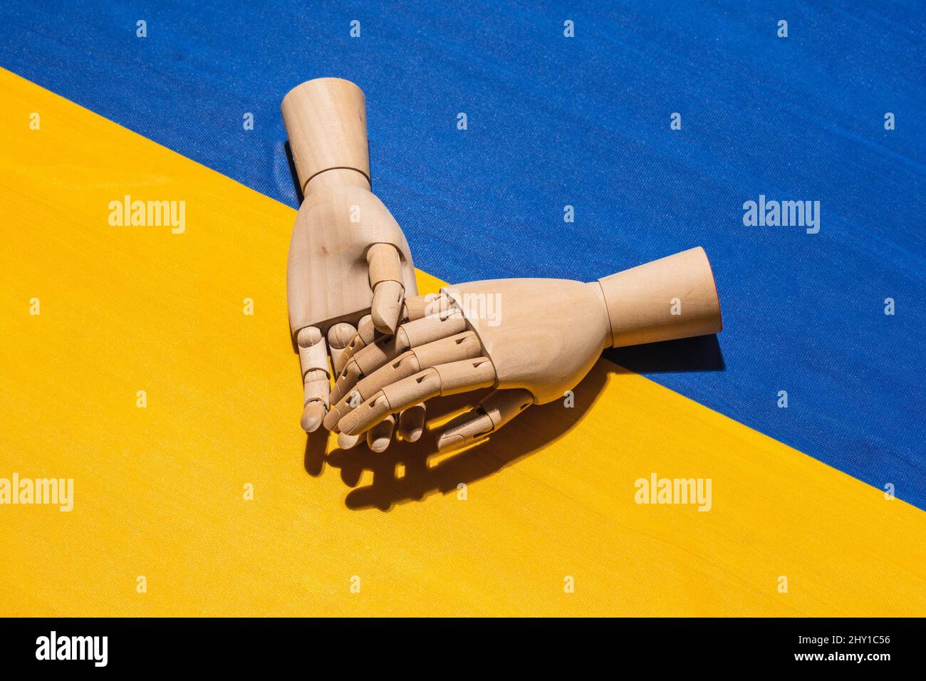 From above of holding wooden mannequin hand representing truce placed ...