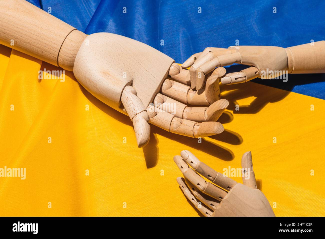 From above of holding wooden mannequin hand representing truce placed ...