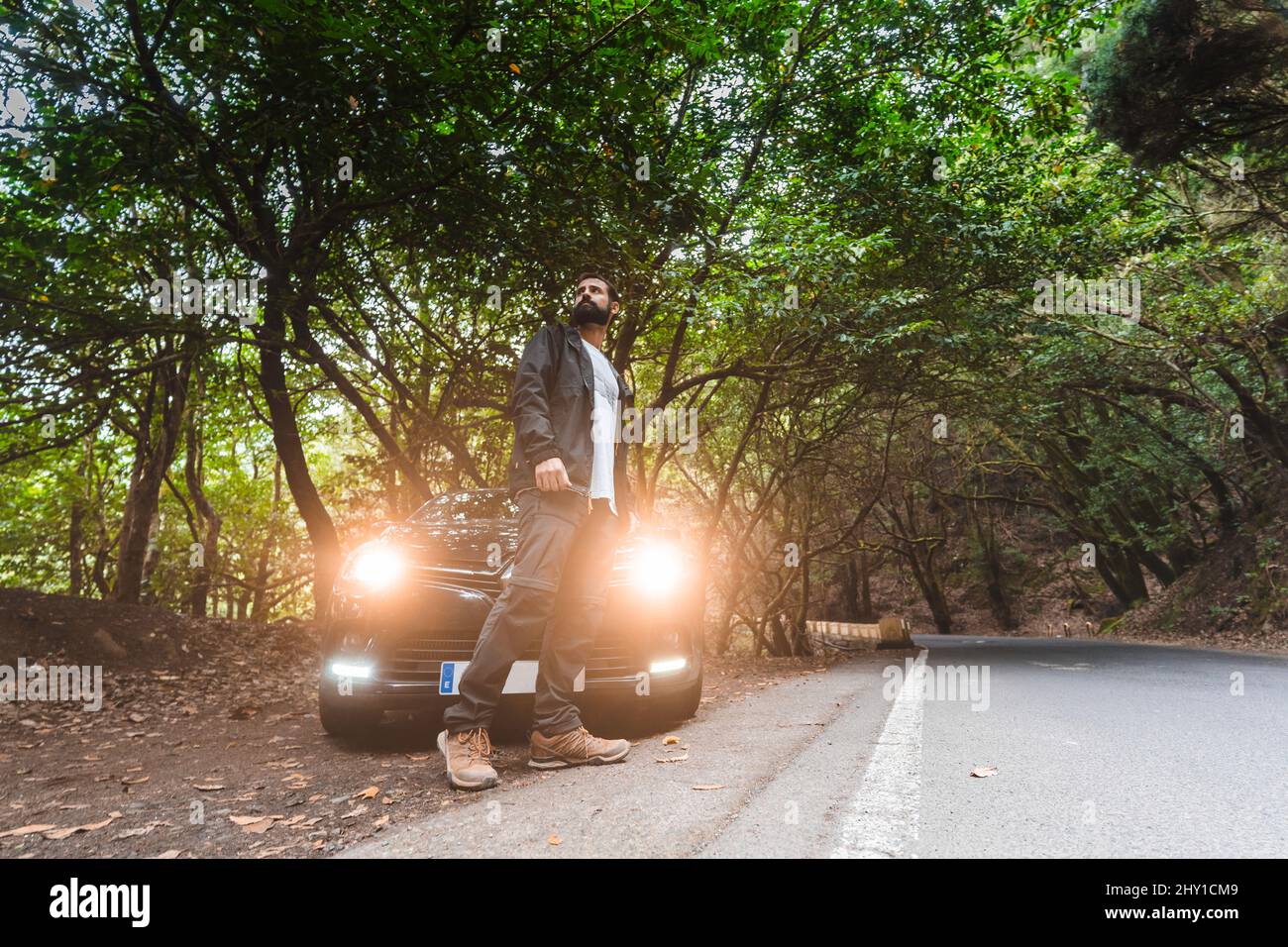Full body of confident bearded male driver standing at modern ...