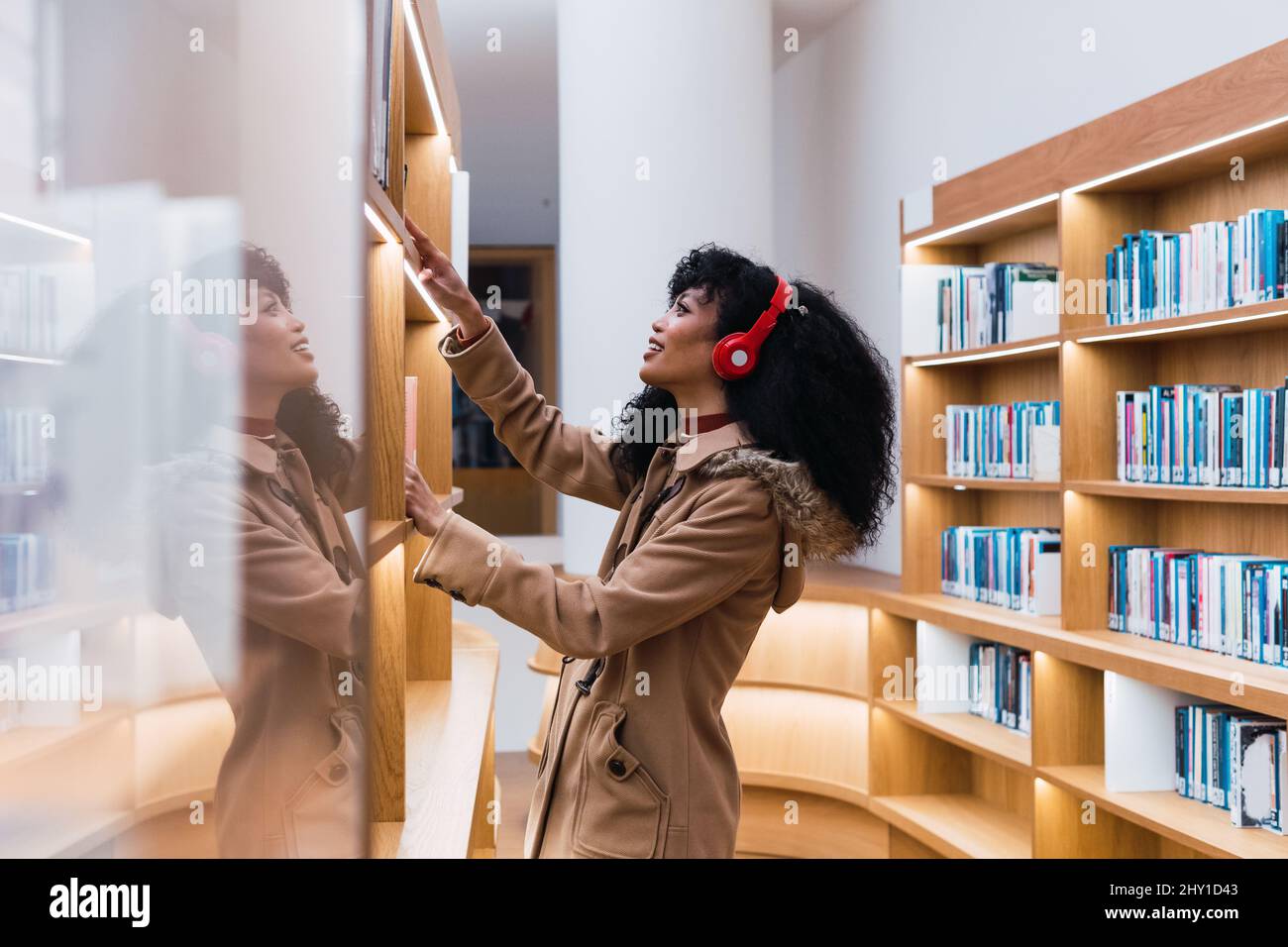 Side view of positive African American lady listening to music and ...