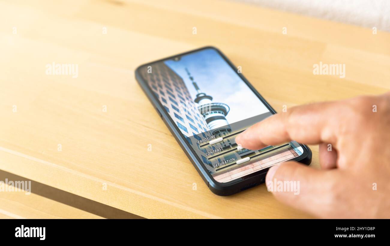 Image of a man editing photography with a mobile phone Stock Photo - Alamy