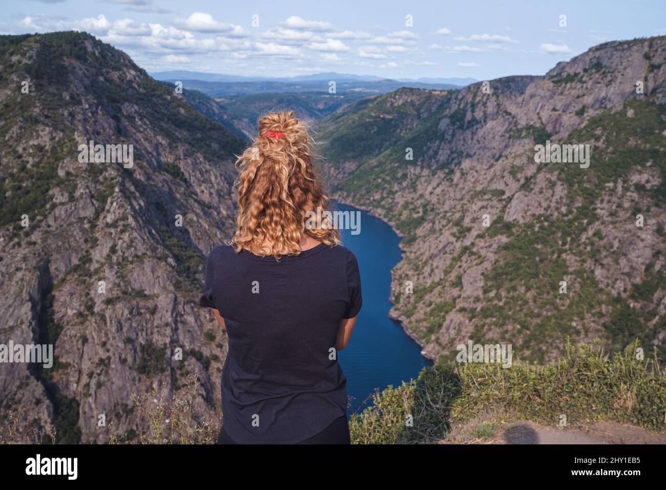 Back view of Woman traveler with curly hair and admiring amazing Sil ...