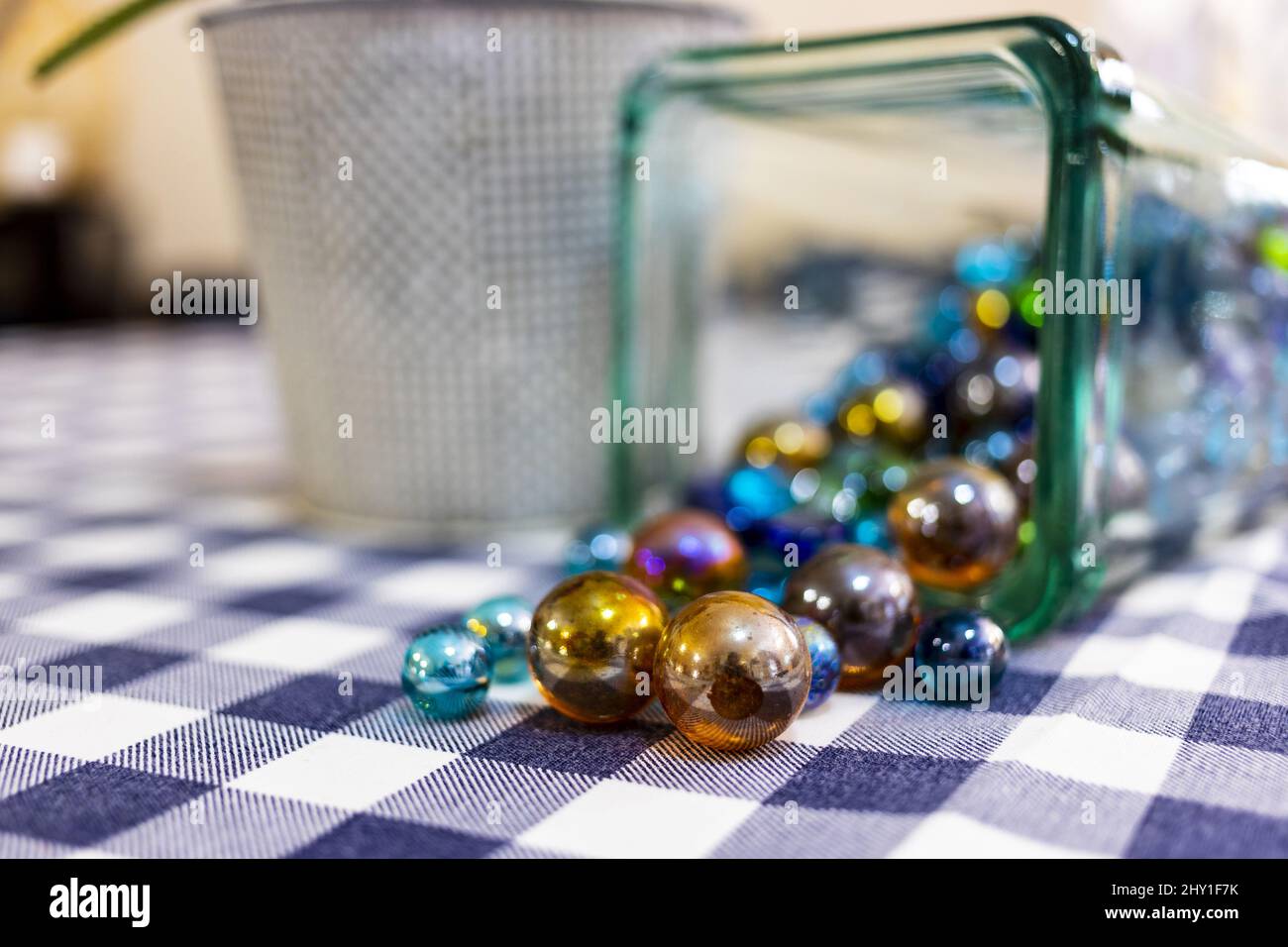 The metallic colorful marbles spilled out from the glass Stock Photo ...