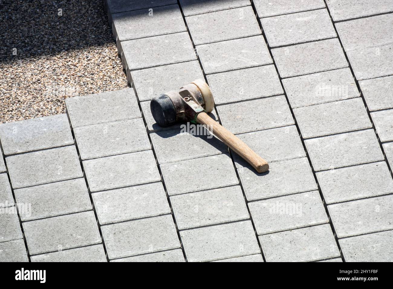 Wooden hammer on a concrete floor slabs on sunny weather Stock Photo ...