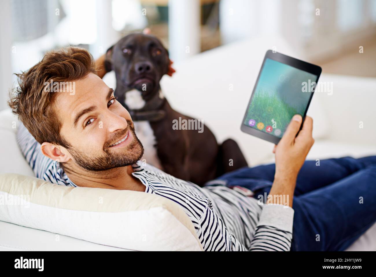 Its one of those hanging-out-on-the-couch days. Man using his tablet on ...