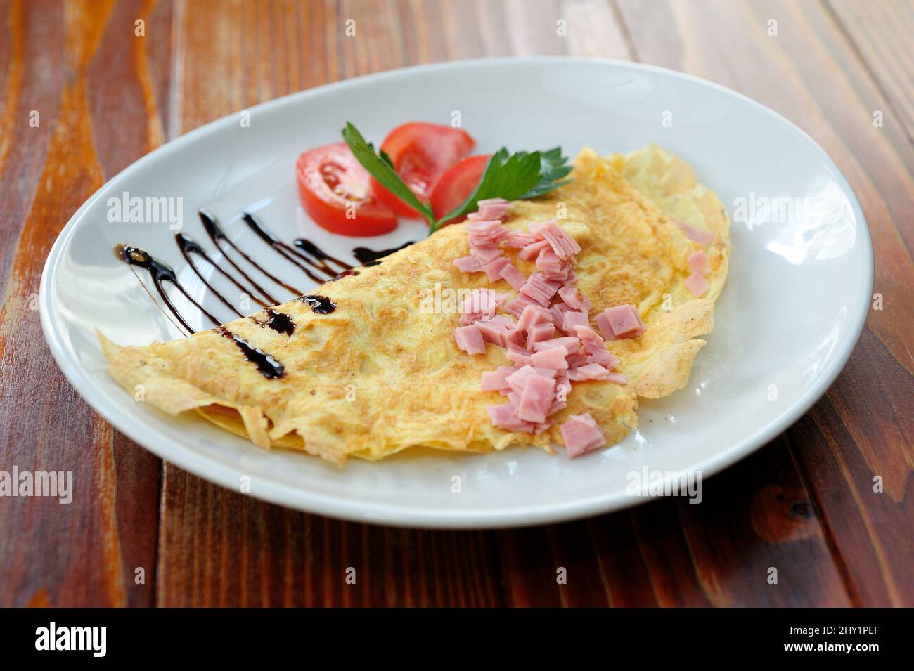 Closeup of a plate filled with an omelet with small slices of ham ...
