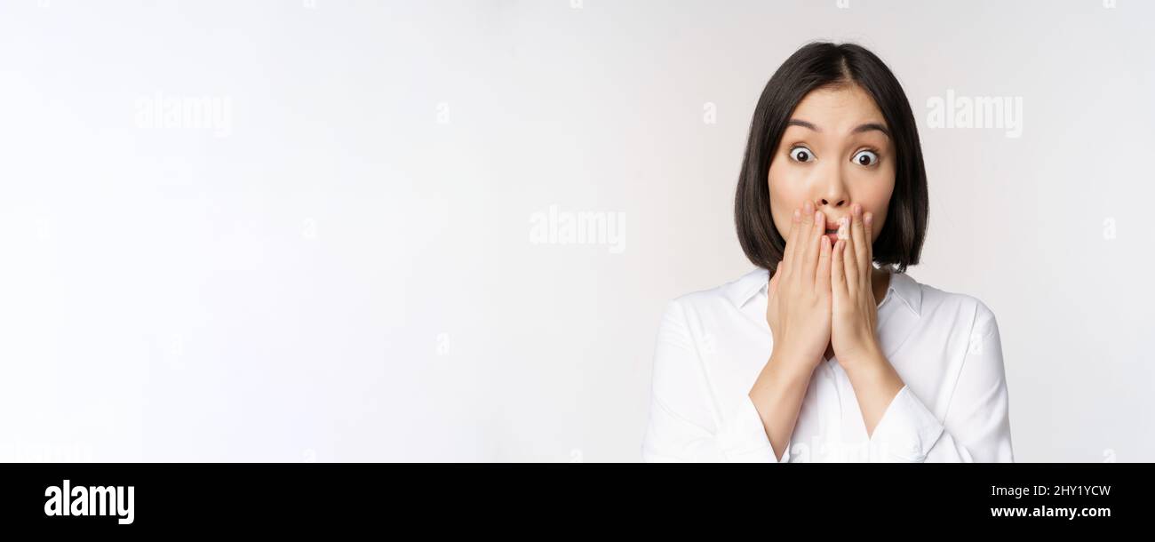 Close up face of asian woman gasping, looking shocked and speechless ...