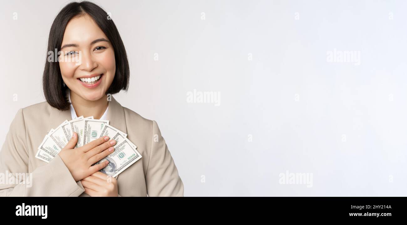 Happy asian businesswoman holding cash, hugging dollars money and ...