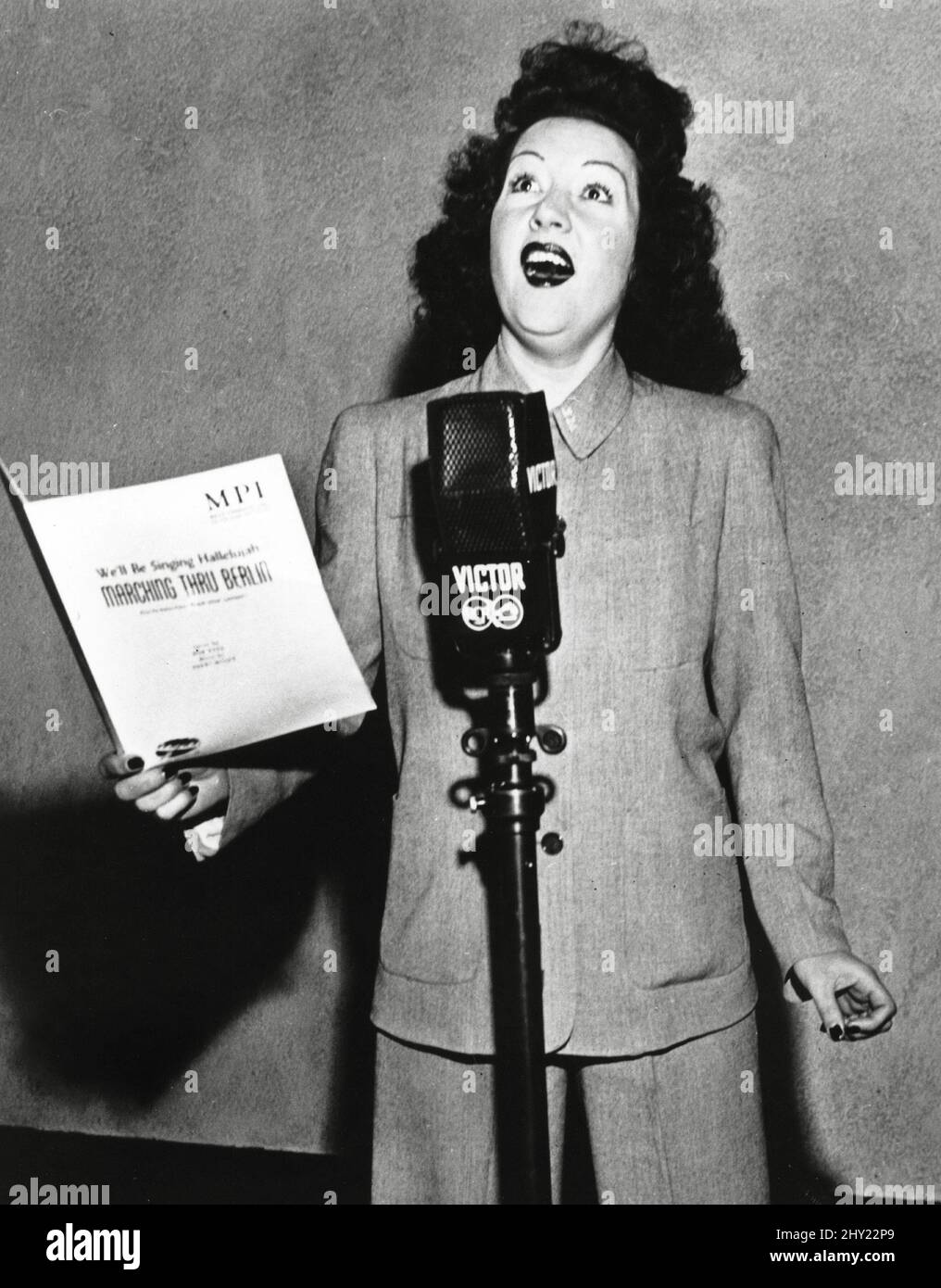 Ethel Merman at a microphone singing (We'll Be Singing Hallelujah ...