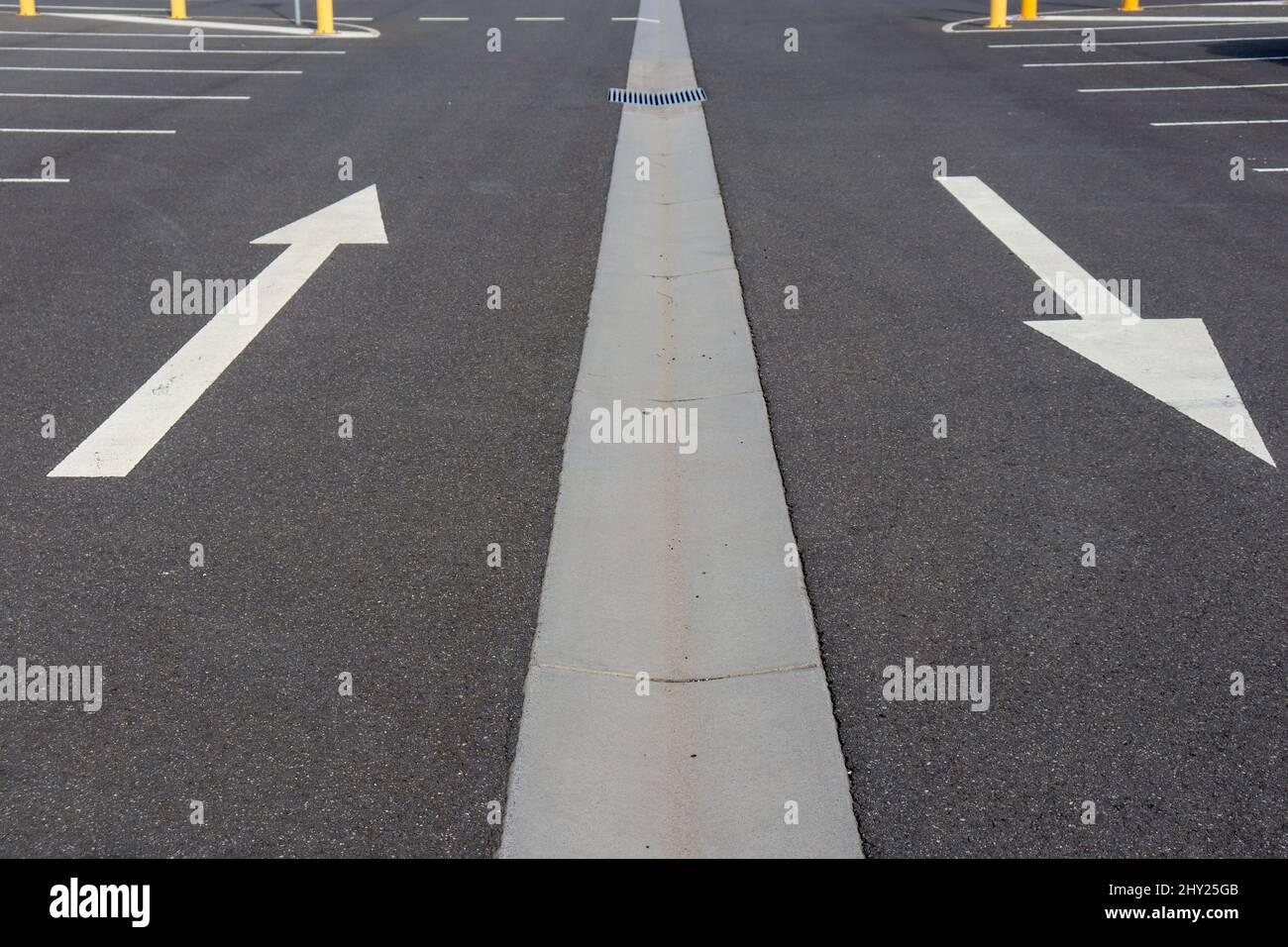 Closeup of two white arrow pointing in opposite directions on car park ...