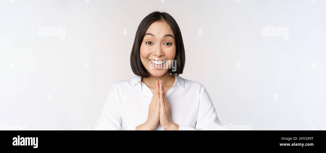 Close up portrait of young japanese woman showing namaste, thank you ...
