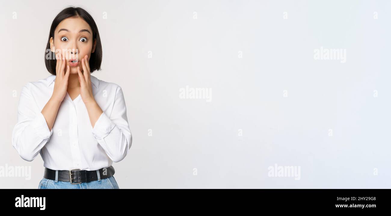 Image of asian female model looking surprised, staring amazed, reacting ...