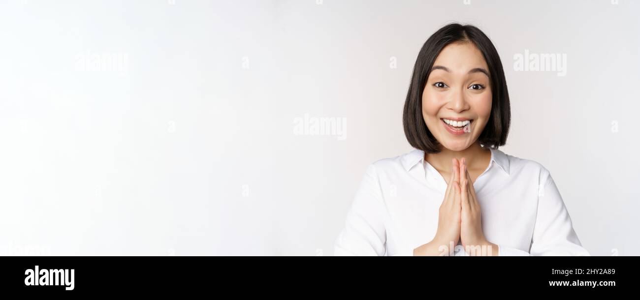 Close up portrait of young japanese woman showing namaste, thank you ...