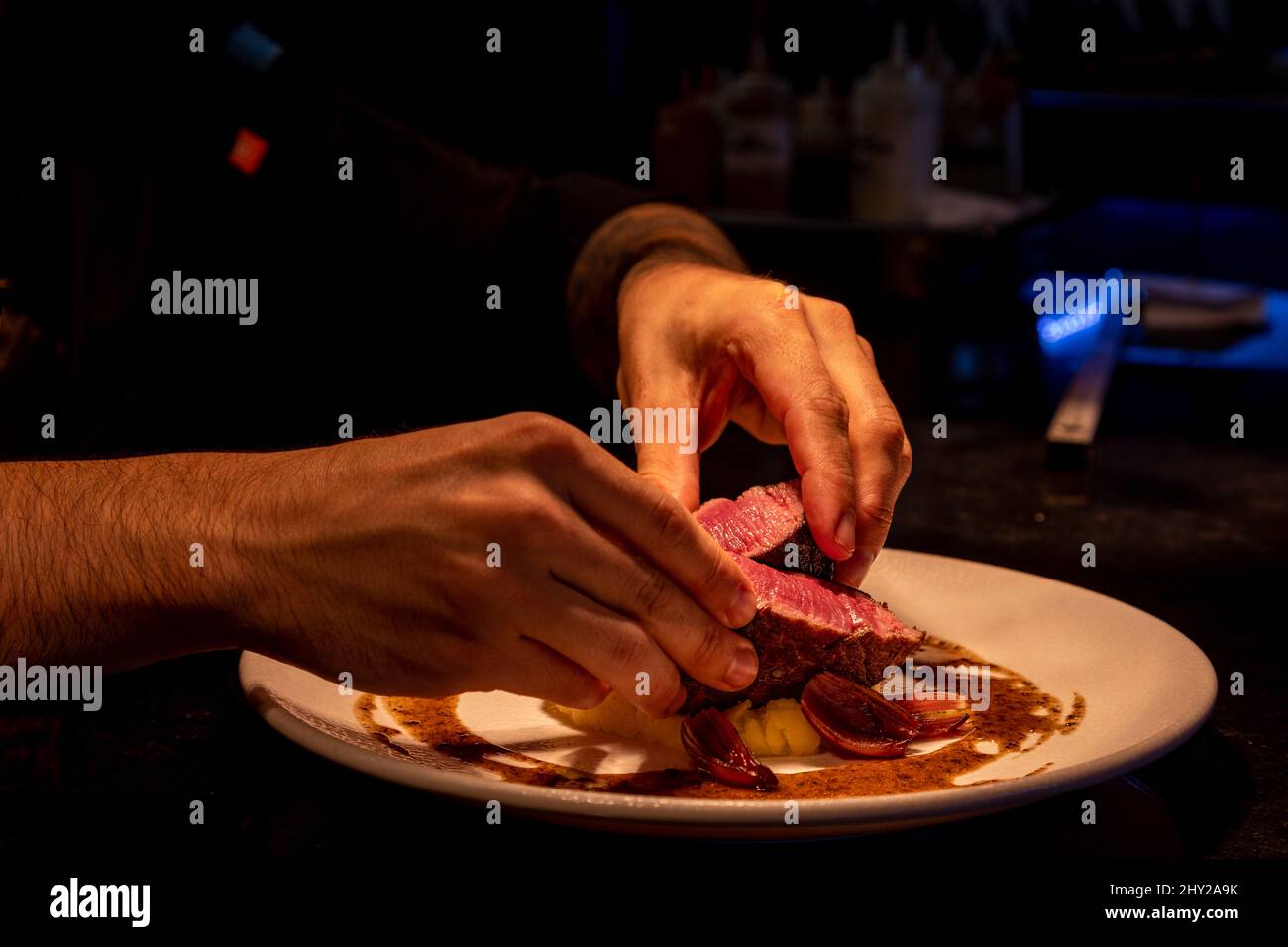 Closeup of male hands serving a steak on the plate in the restaurant ...