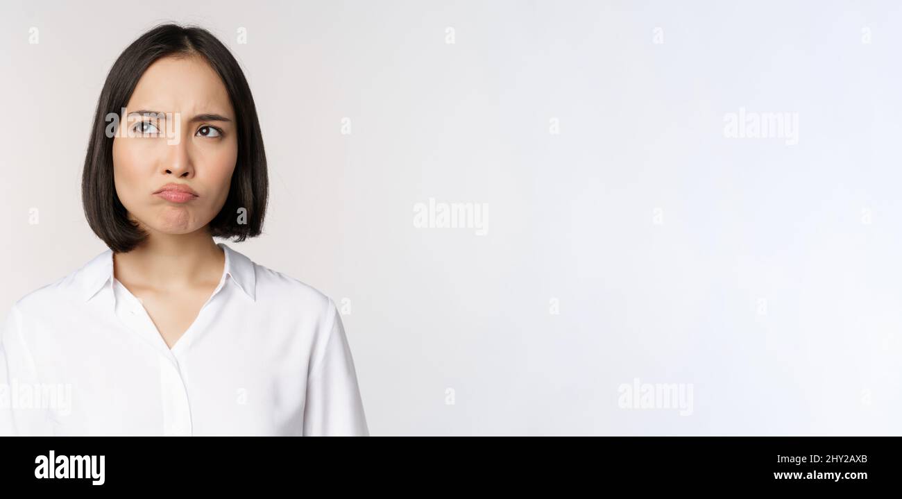 Close up head portrait of young asian woman looking upset and ...