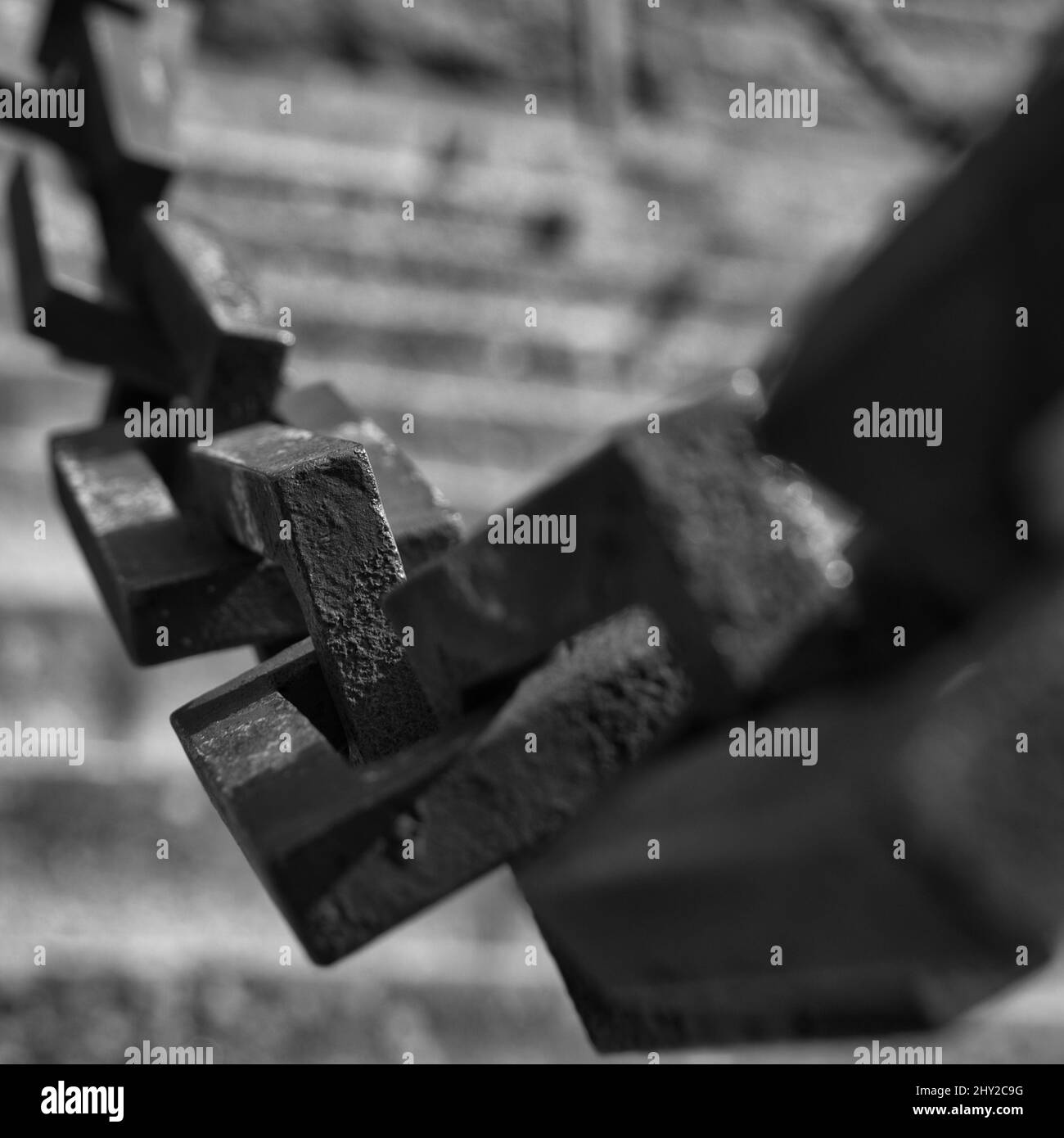Grayscale shallow focus of big metal chain with squares on a sunny day ...