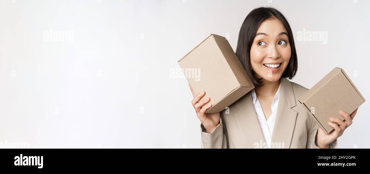 Image of asian saleswoman shaking boxes and guessing whats inside ...