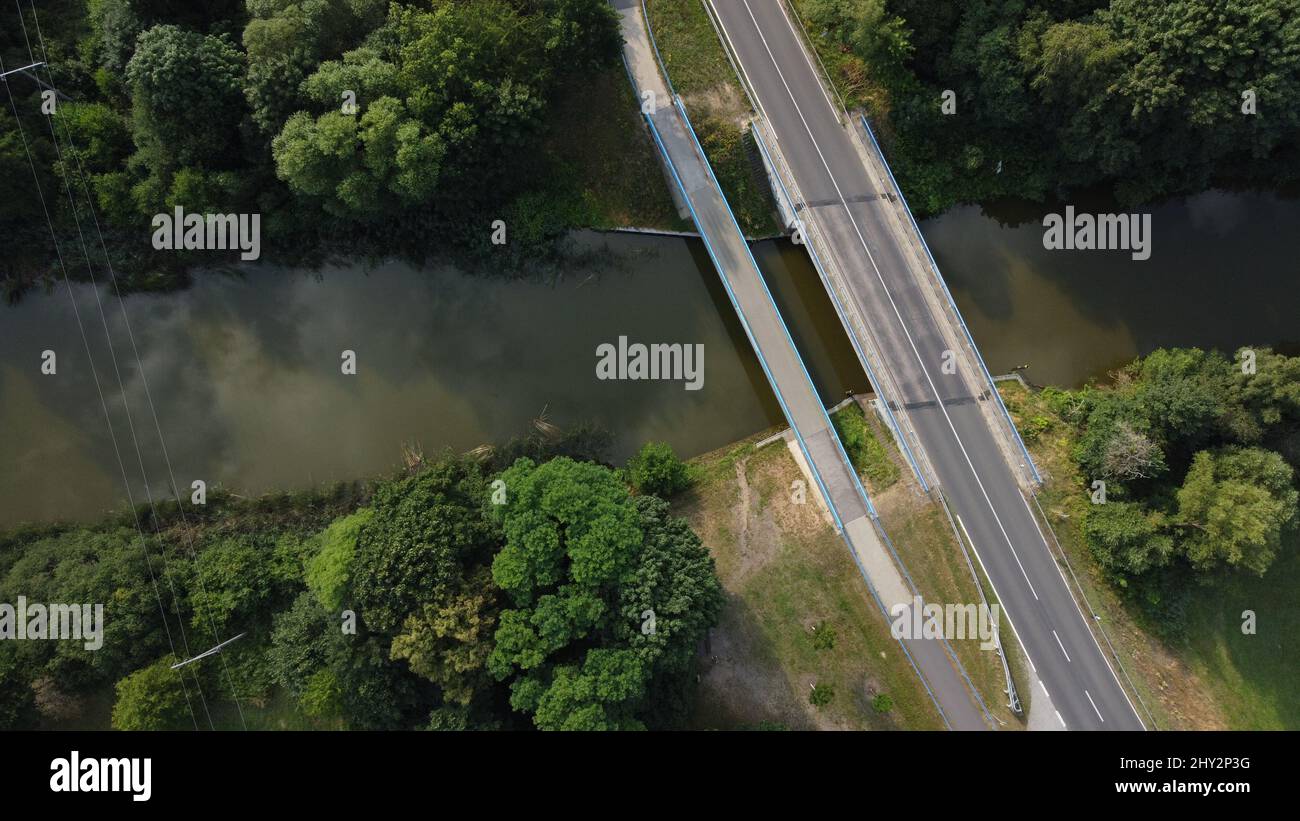Aerial view of a road bridge over the flowing river in the countryside ...
