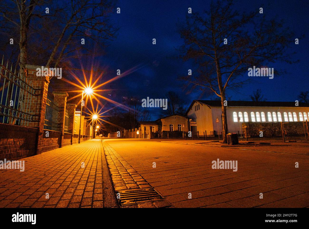 Beautiful view of an empty street gleaming under the cloudy night sky ...