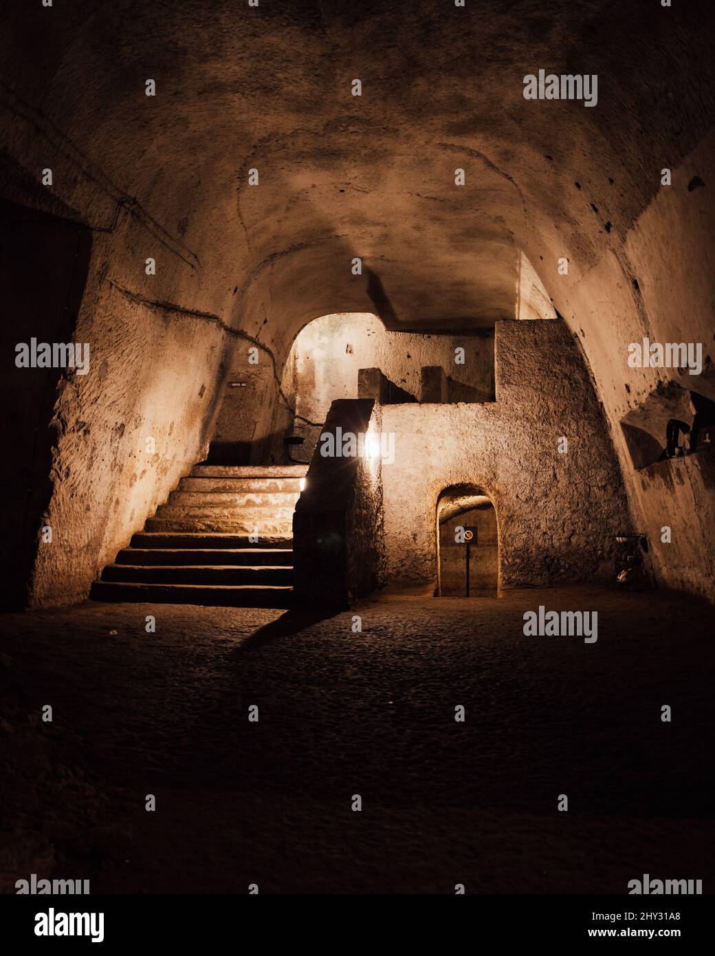 View of a an underground hall with arched ceiling and stone walls and ...